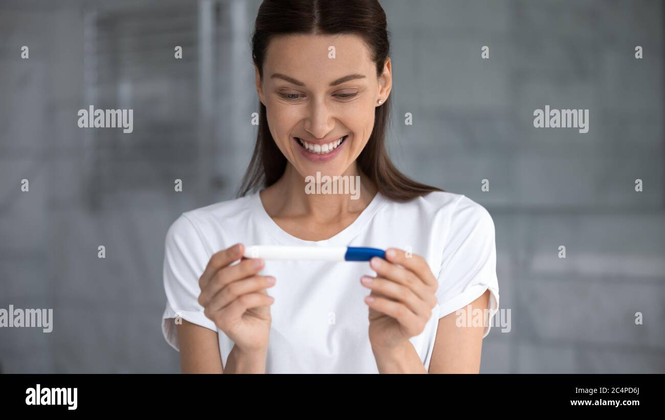 Happy young woman excited with positive pregnancy test result Stock ...