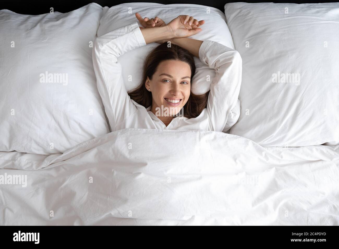 Happy woman lying relaxing in cozy bed at home Stock Photo - Alamy