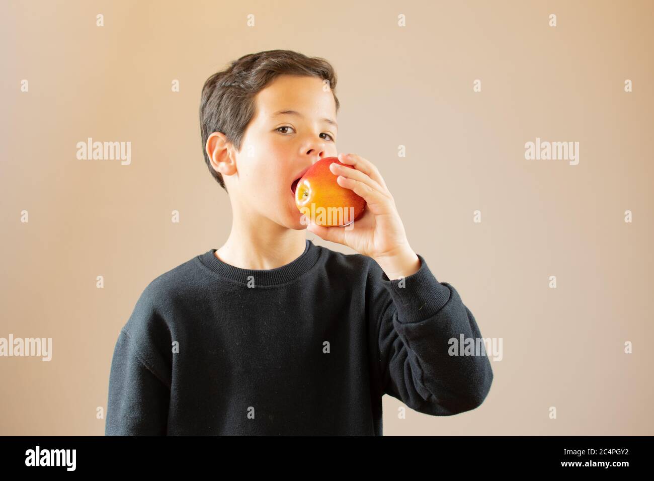 Young boy eating an apple Stock Photo - Alamy