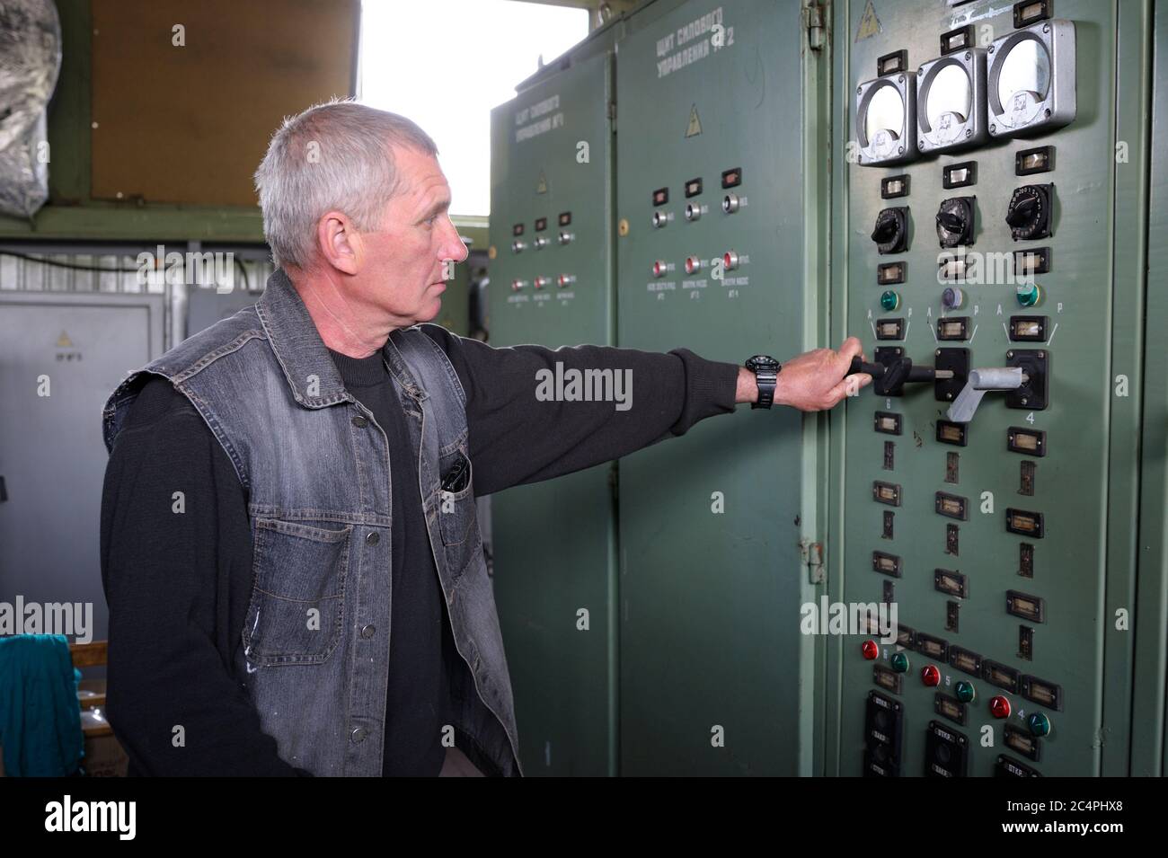 At the control operations room. Worker turning tumblers on a main ...