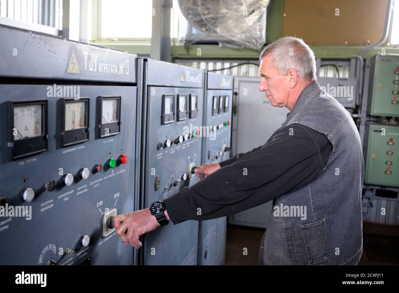 At the control operations room. Worker turning tumblers on a main ...