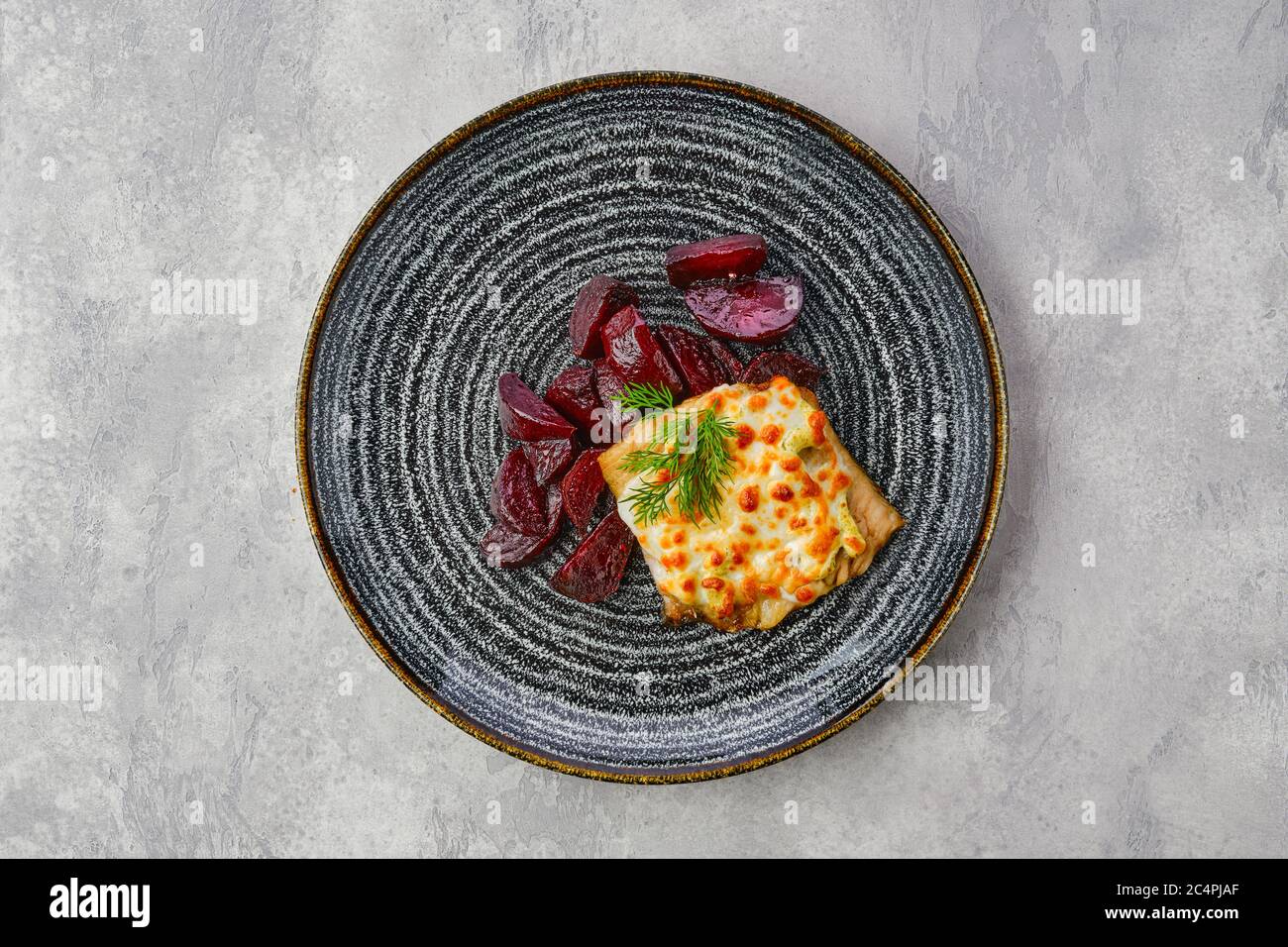 Top view of fried cod fillet with melted cheese topping and roasted ...