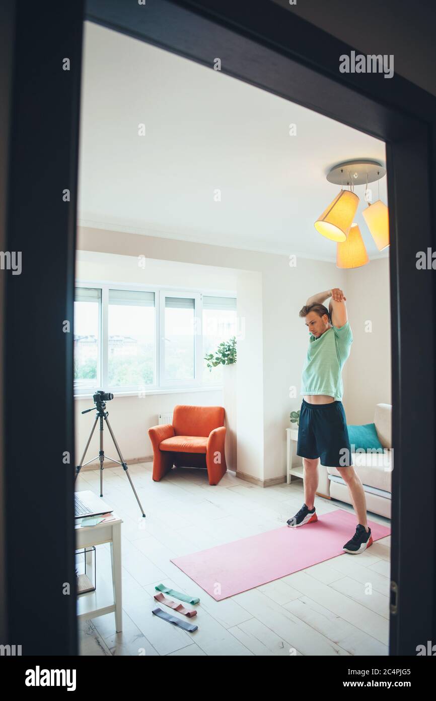 Side view photo of a caucasian fitness trainer having online lessons ...