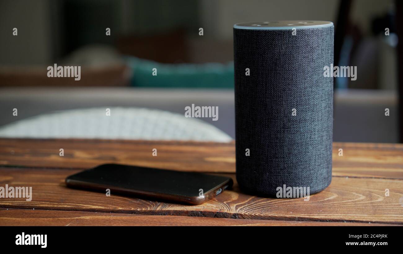 Dark grey Black Amazon Alexa Echo and smart phone on the wooden table ...