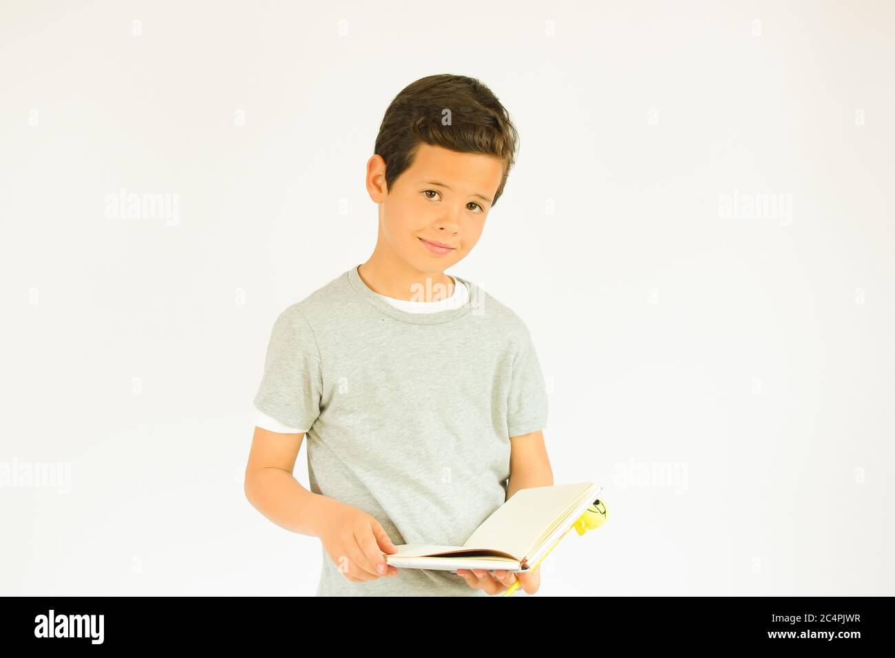 Young boy taking notes in book Stock Photo - Alamy