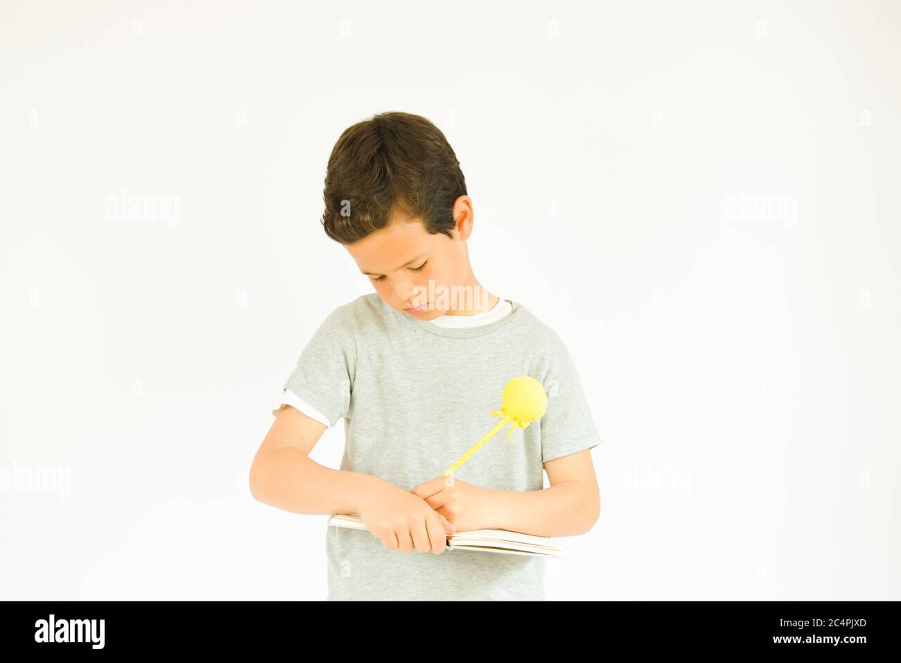 Young boy taking notes in book Stock Photo - Alamy
