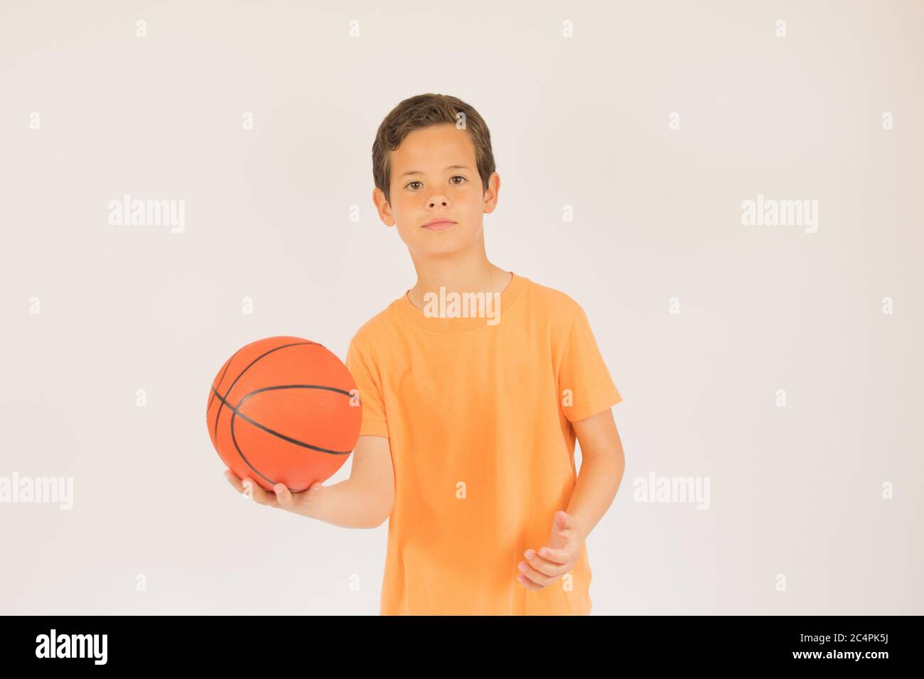 Boy with basketball looking into camera Stock Photo - Alamy