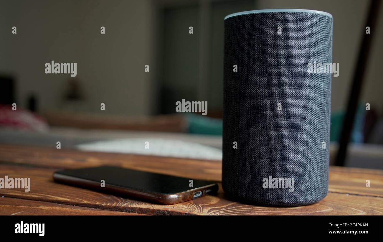 Dark grey Black Amazon Alexa Echo and smart phone on the wooden table ...