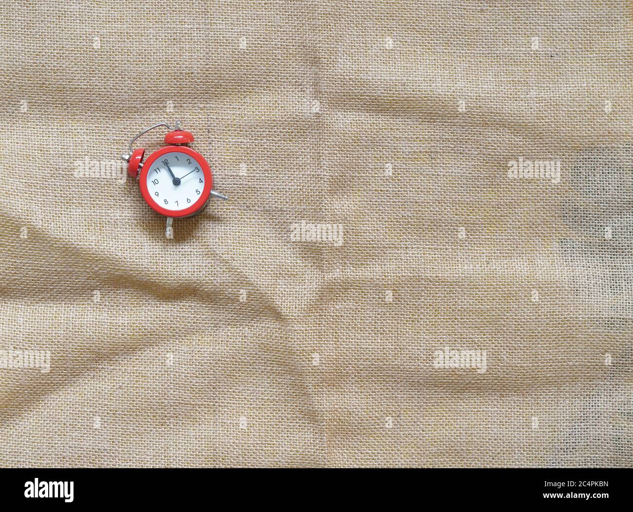 Creative flat lay vintage clock on red office table top view background ...