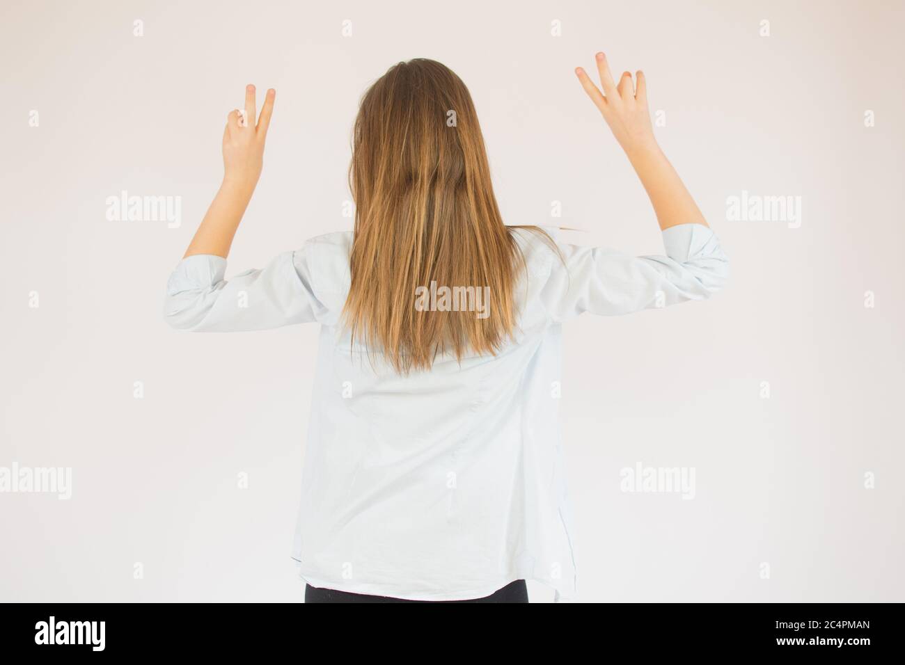 Beautiful young girl making a victory pose Stock Photo - Alamy