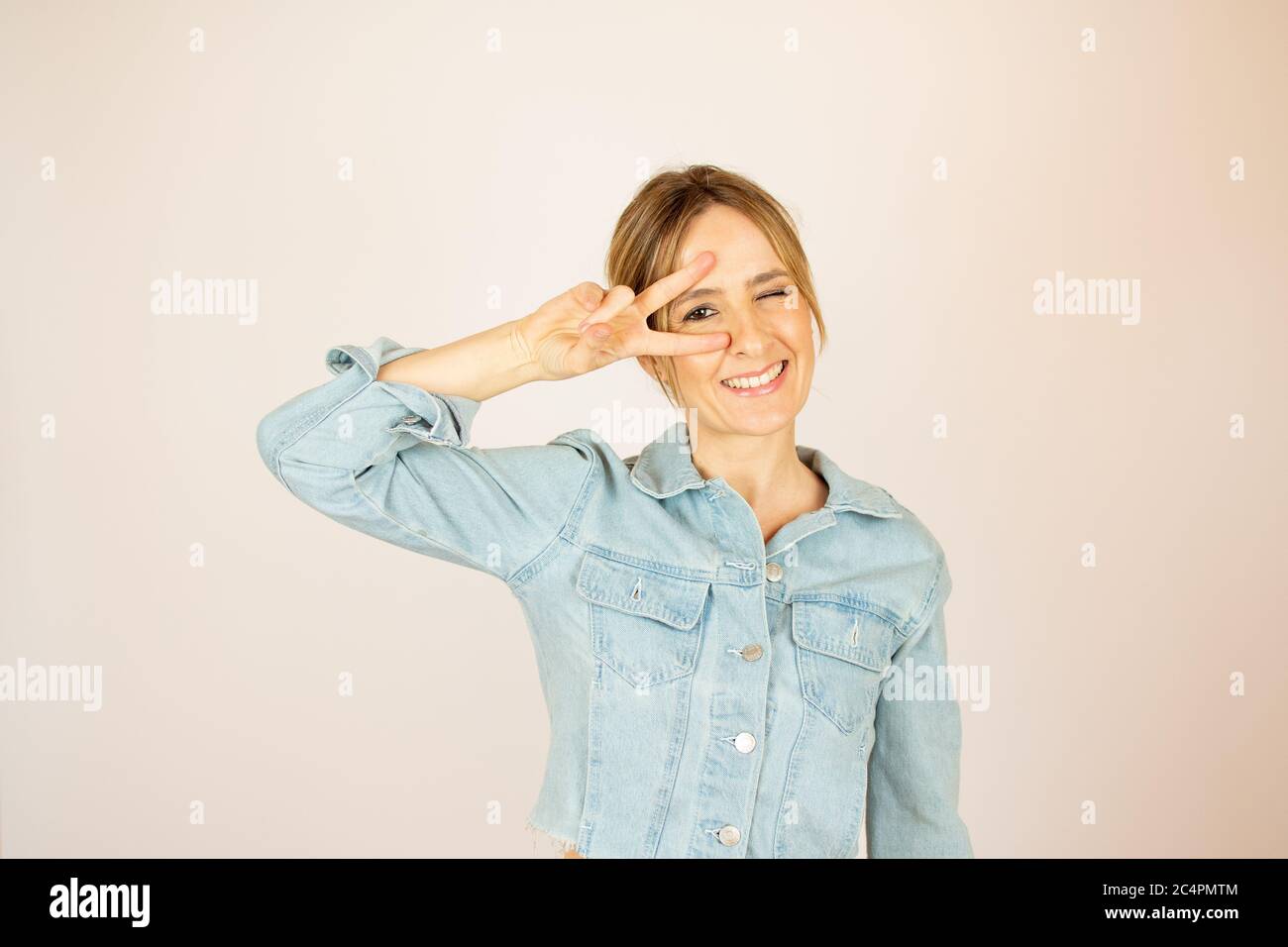 Young woman making a eye gesture Stock Photo - Alamy
