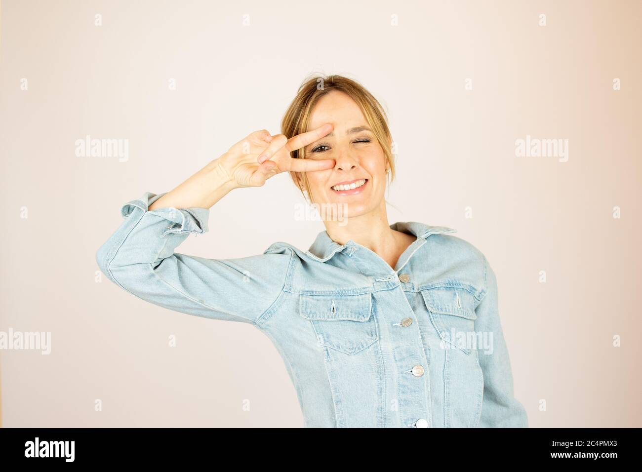Young woman making a eye gesture Stock Photo - Alamy