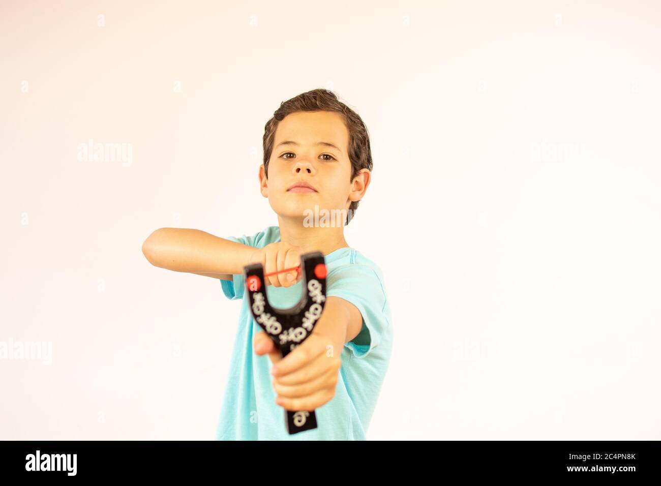 Handsome boy playing with a slingshot Stock Photo - Alamy