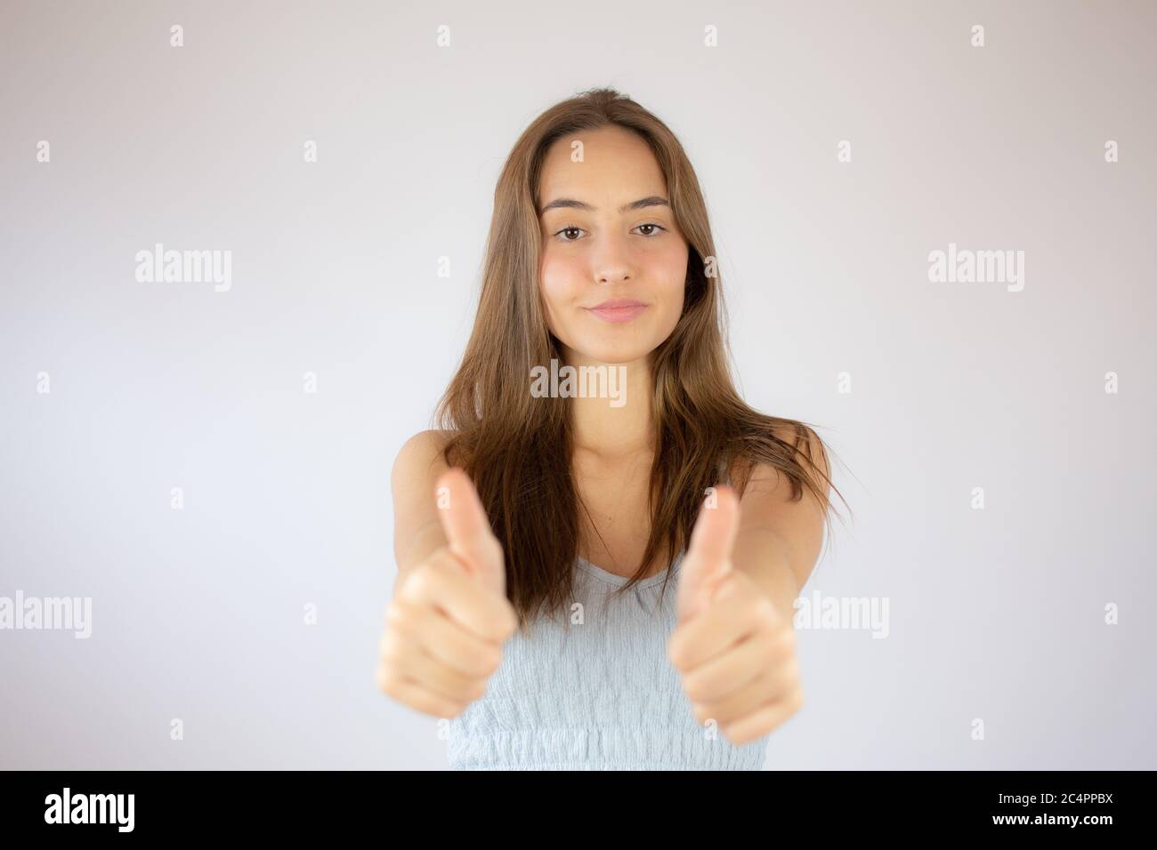 Pretty young girl making fingers up gesture Stock Photo - Alamy