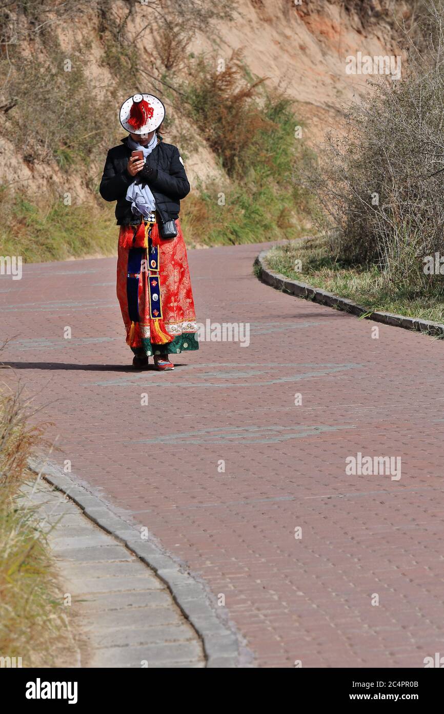 Yugur girl-absorbed in mobile phone-ethnic attire-way to Puguang-Temple ...