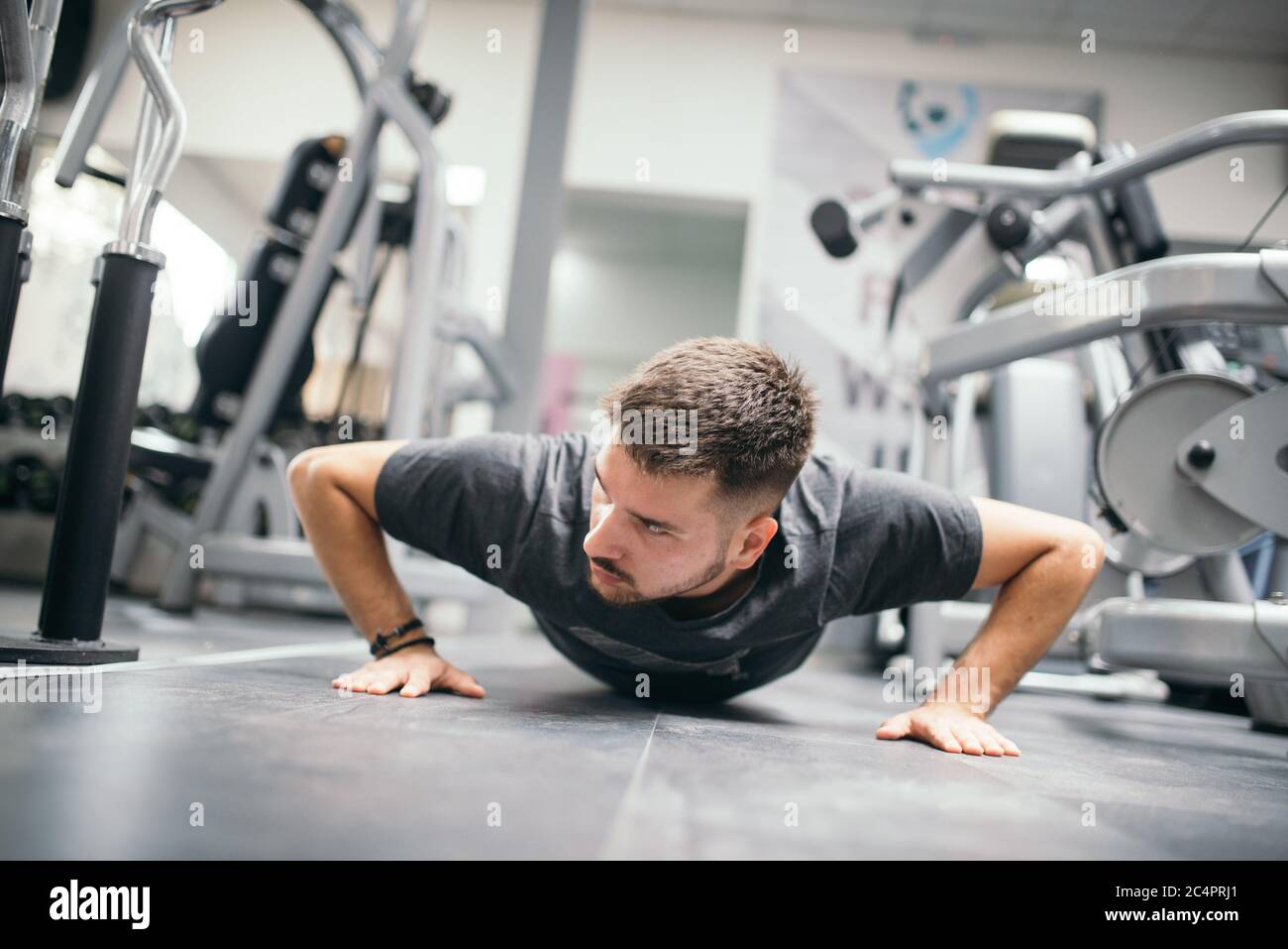 Muscular attractive guy doing push-ups in gym Stock Photo - Alamy