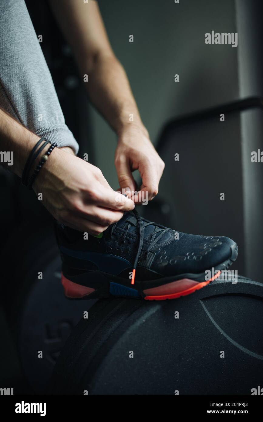 Close-up athlete tying his shoe in gym Stock Photo - Alamy