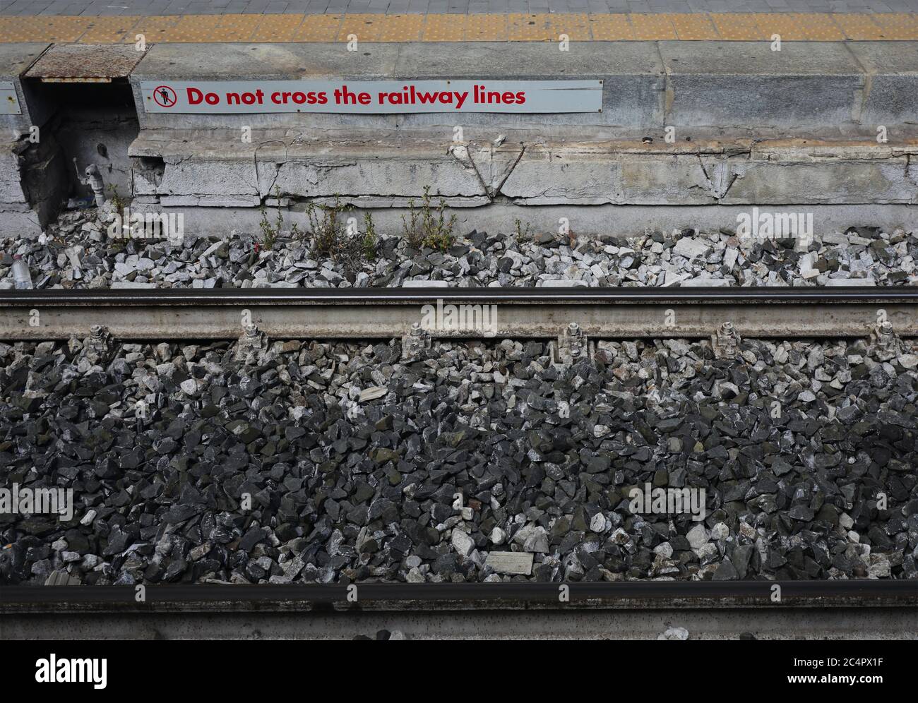 large TEXT in English that warns people not to cross the railroad ...