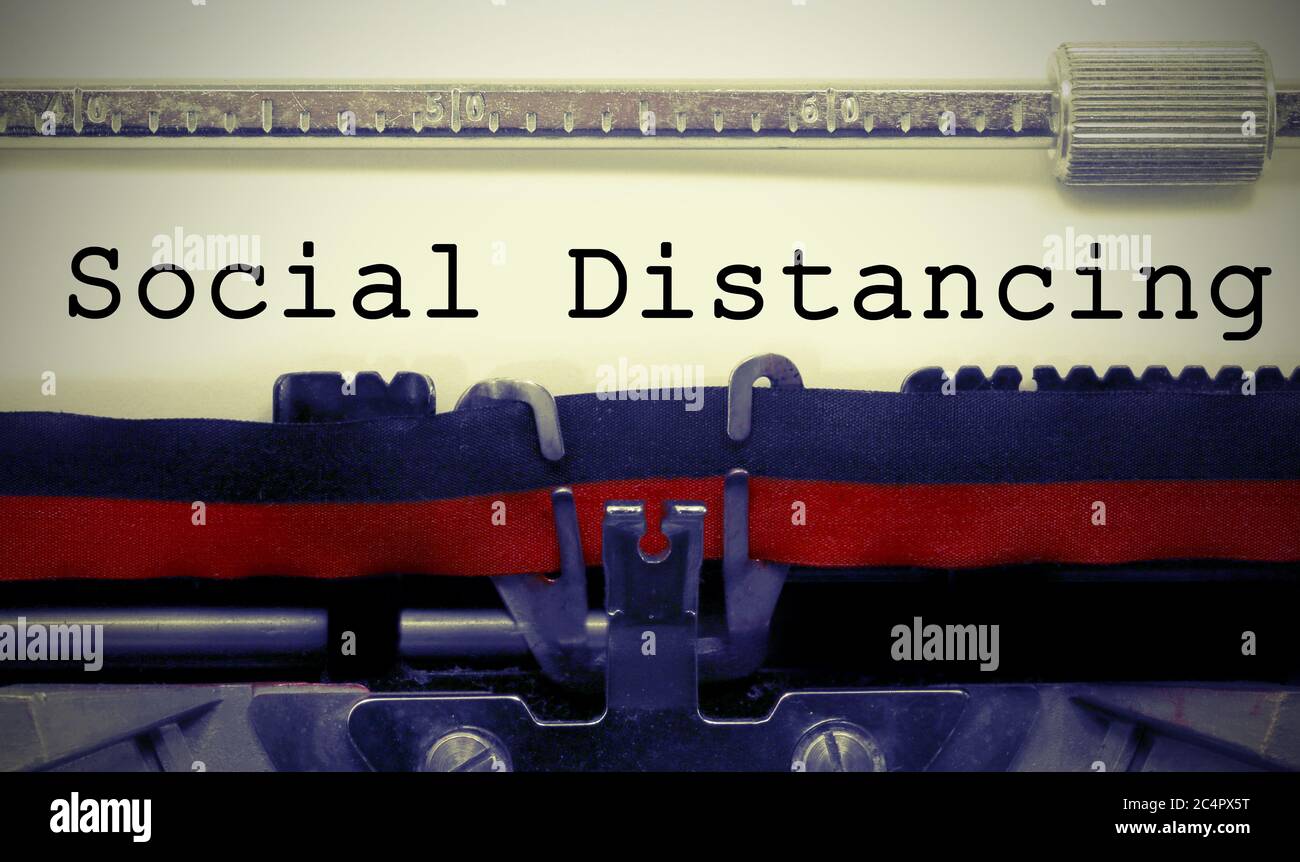 Social Distancing text on white sheet in vintage typewriter with black ...