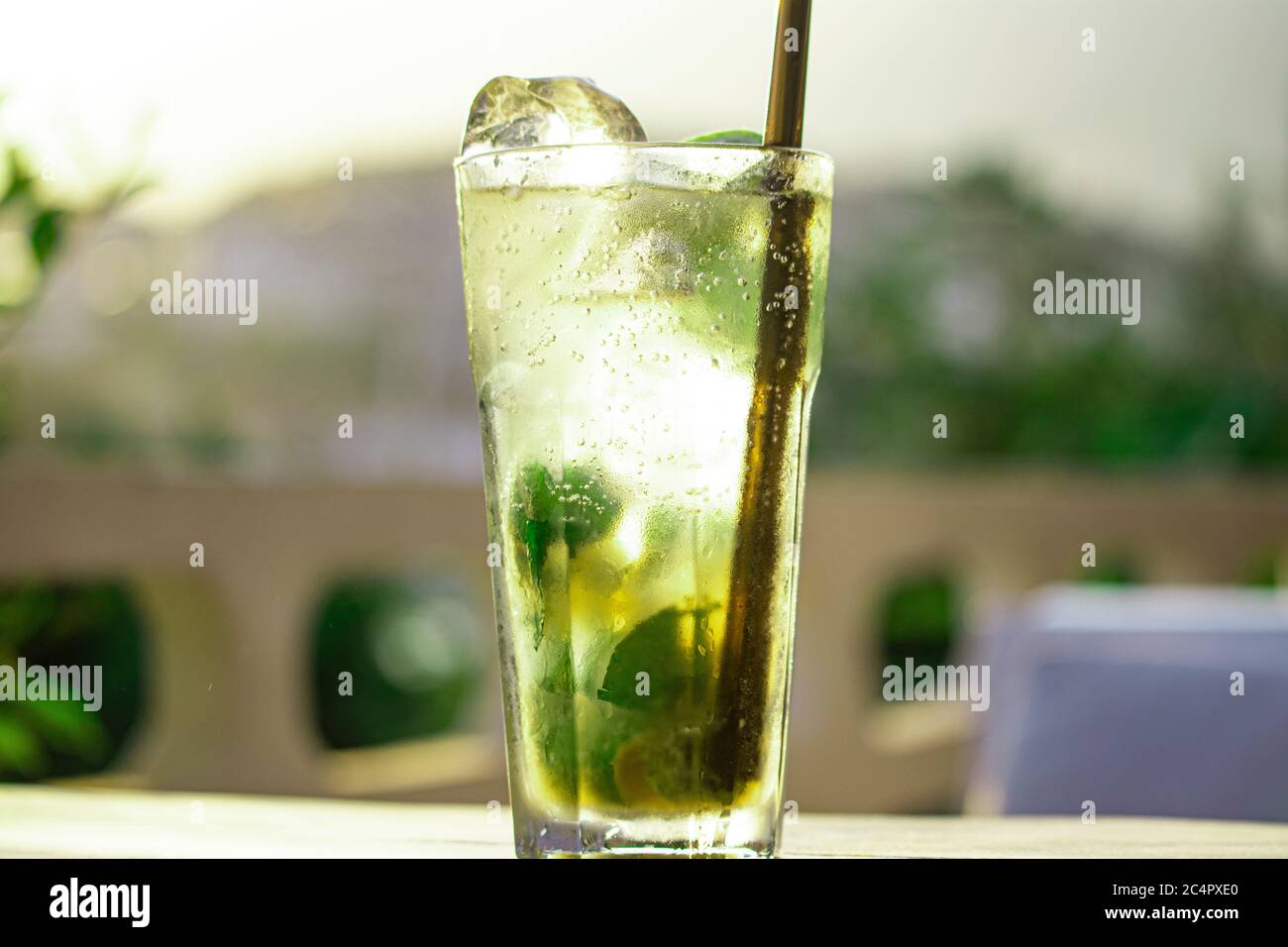 Delicious alcoholic cocktail mojito on the table with cafe landscape ...