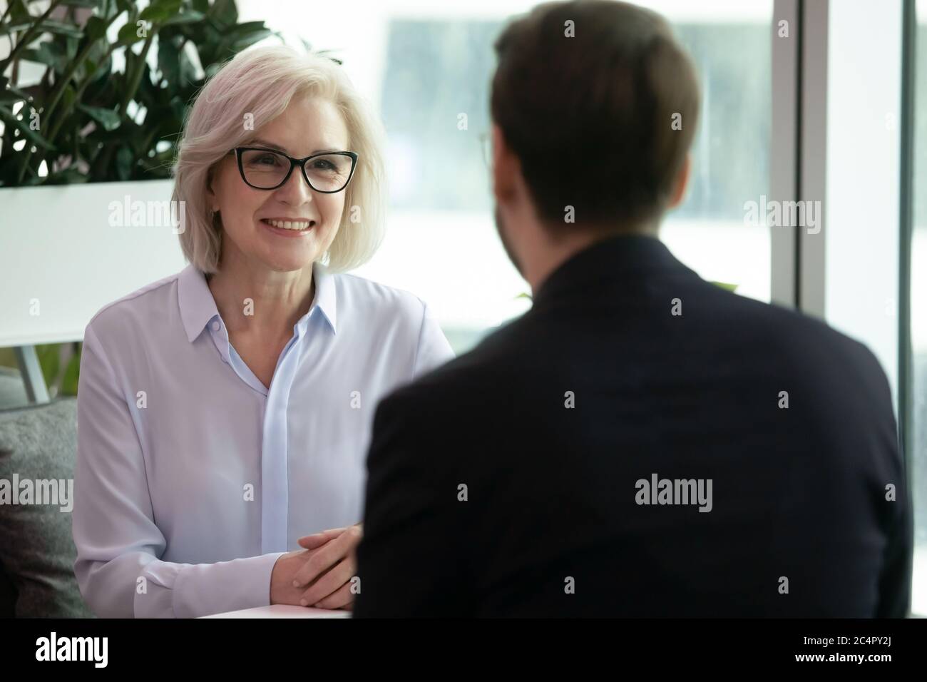 Female boss communicate with subordinate and smile Stock Photo - Alamy
