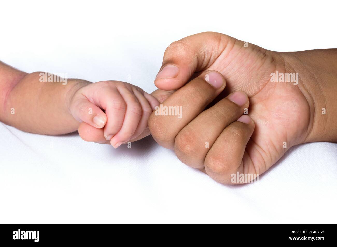Index finger of a young boy held by a newborn baby in a white ...