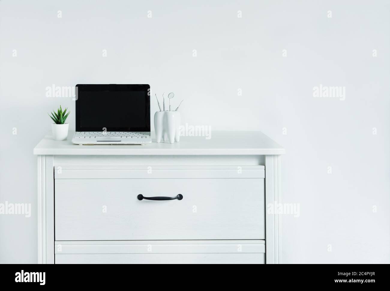Dentist table with laptop and teeth model. Computer with blank screen ...