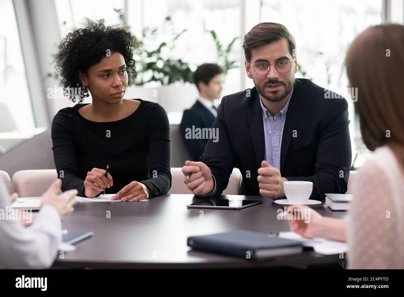 Millennial business man speaking to diverse team training brainstorming ...