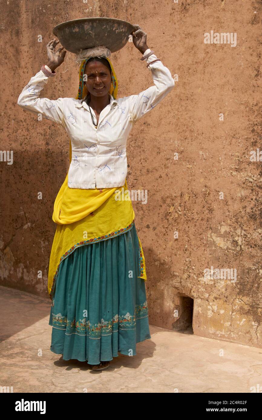 Female laborers transporting water and plaster in bowls carried on the ...