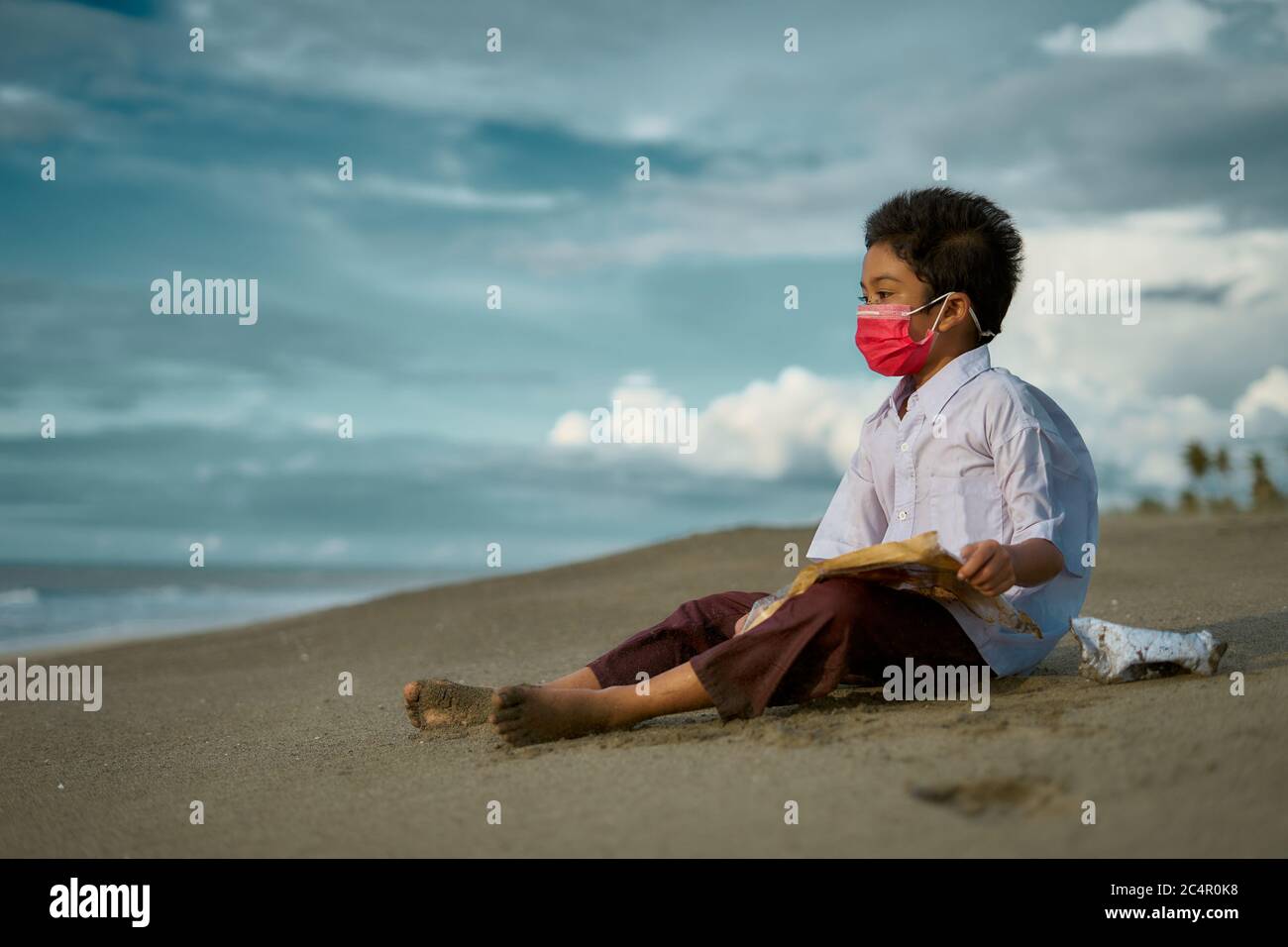 Little boy study hard, doing homework outdoor under cloud and blue sky ...