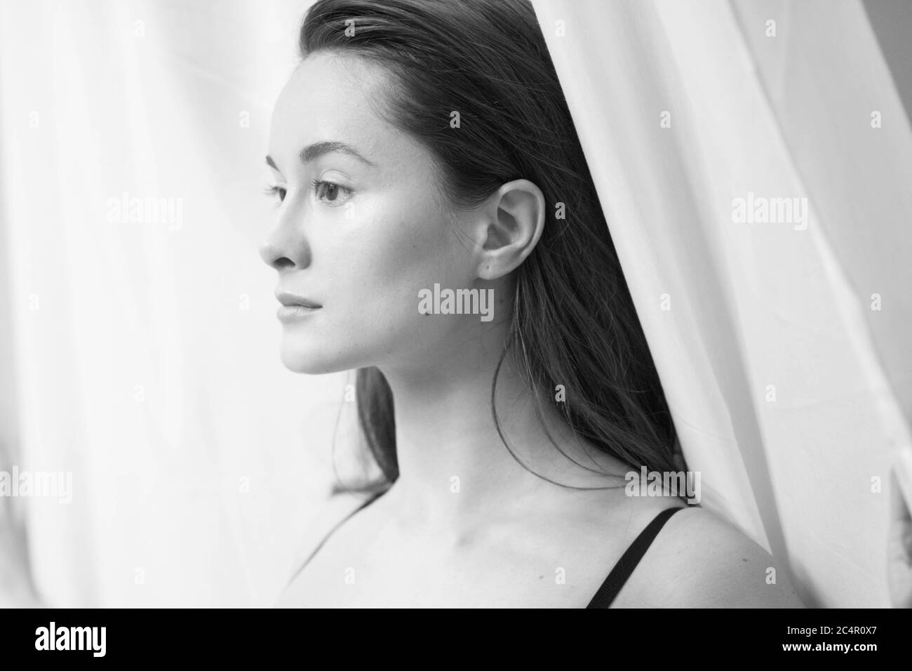 Woman at window with curtain Black and White Stock Photos & Images - Alamy