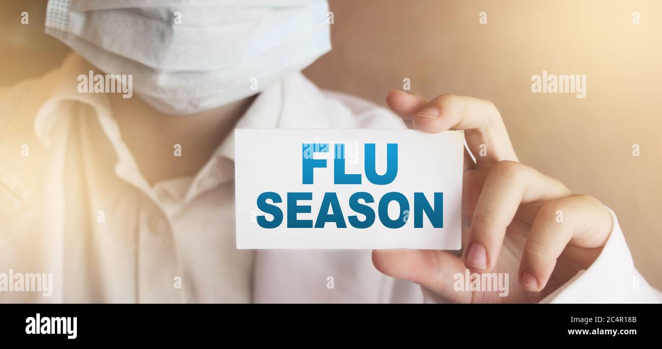 Doctor holding a card with Flu Season medical concept Stock Photo - Alamy