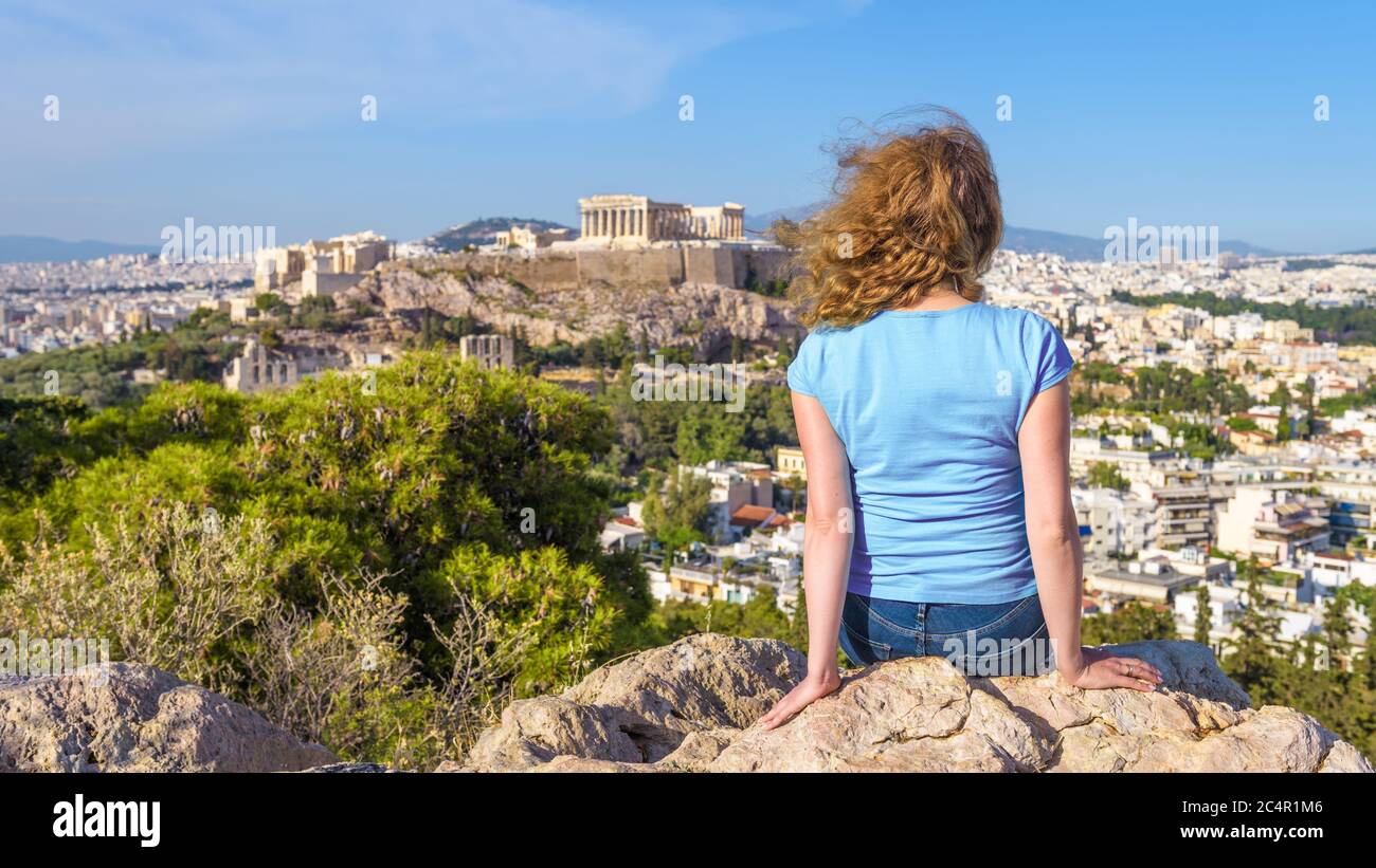 Young woman looks at cityscape of Athens, Greece. Adult girl tourist ...