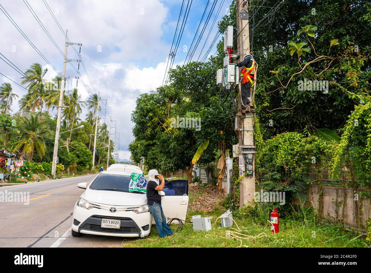 A professional electrician performs installation work on a pole. An ...