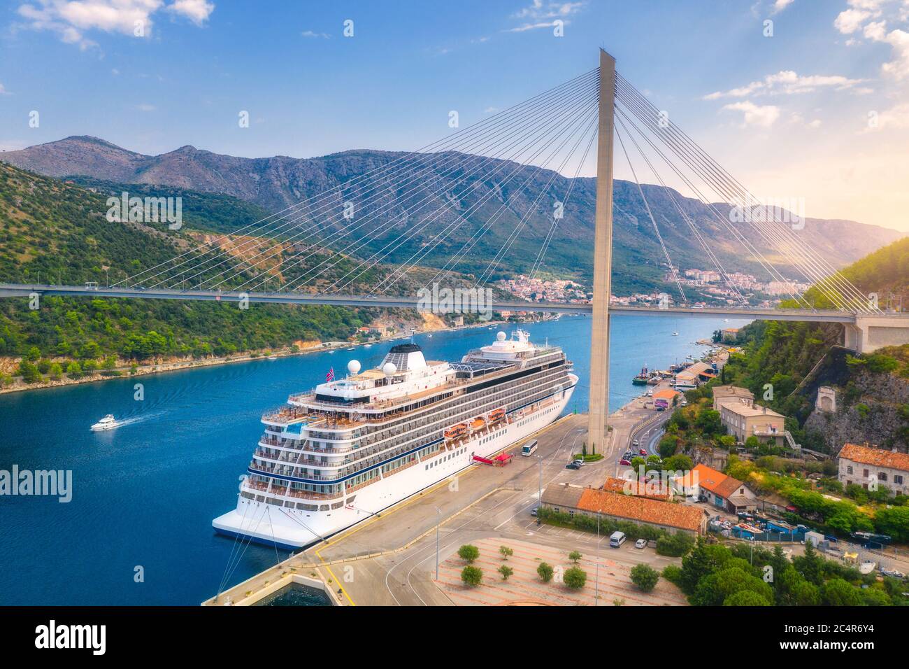 Aerial view of cruise ship under beautiful bridge at sunset Stock Photo ...