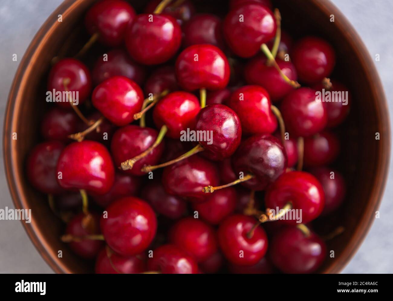Bowl of red cherries shot from above in flat lay style.Delicious sour ...