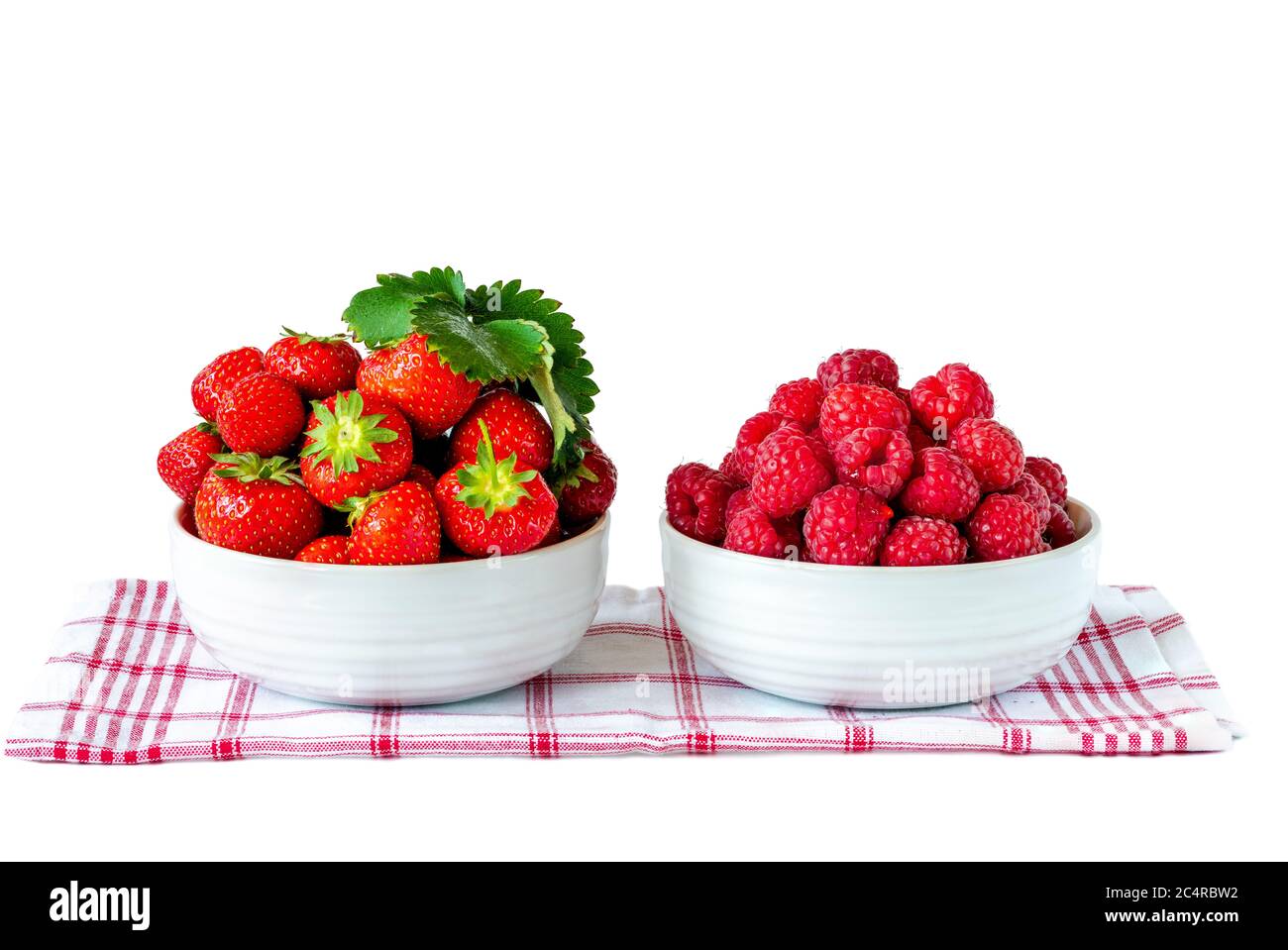 Fresh raspberries and strawberries in bowls isolated on white ...