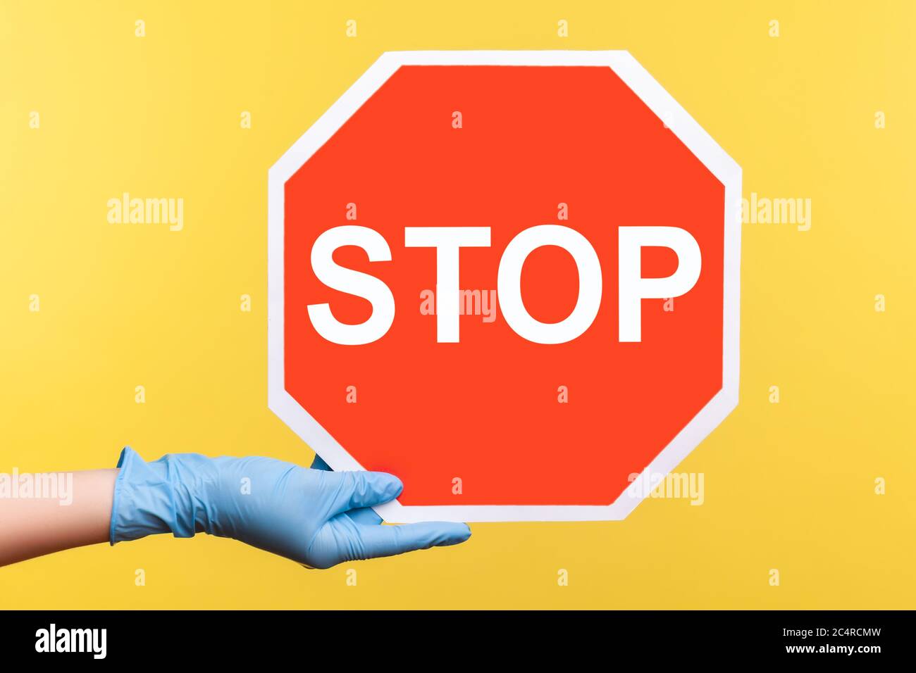 Profile side view closeup of human hand in blue surgical gloves holding ...