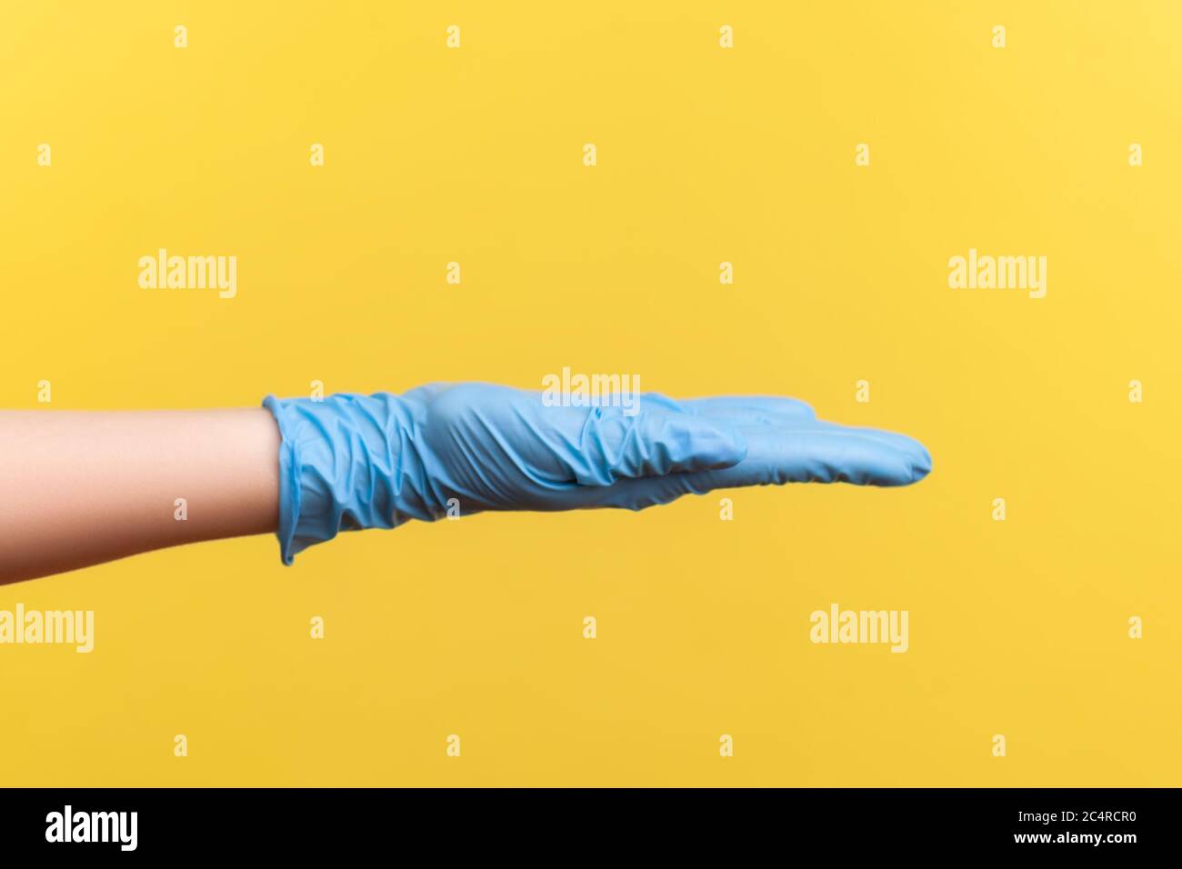 Profile side view closeup of human hand in blue surgical gloves showing ...