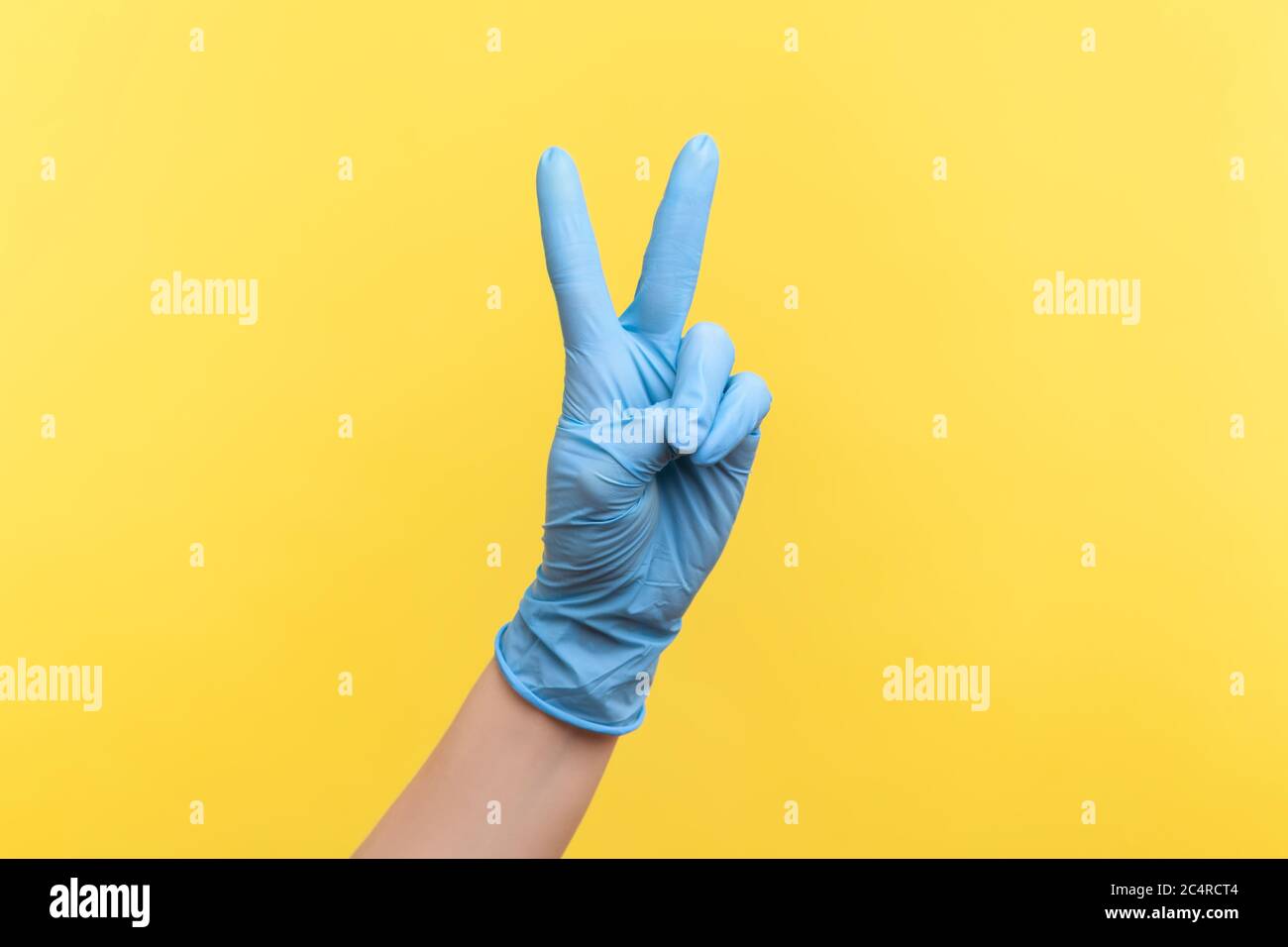 Profile side view closeup of human hand in blue surgical gloves showing ...