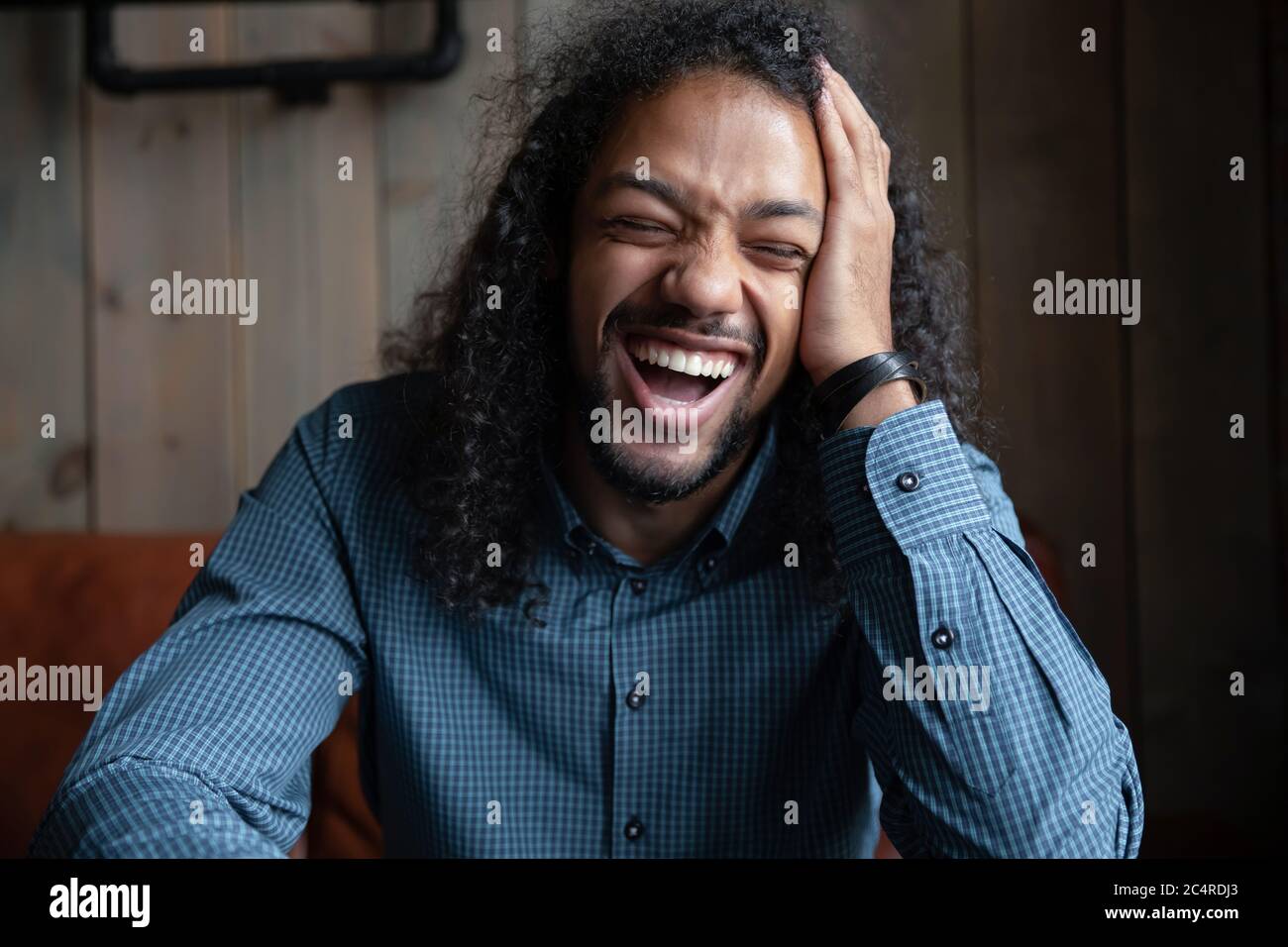 Headshot hilarious cheerful long-haired African guy laughing over joke ...
