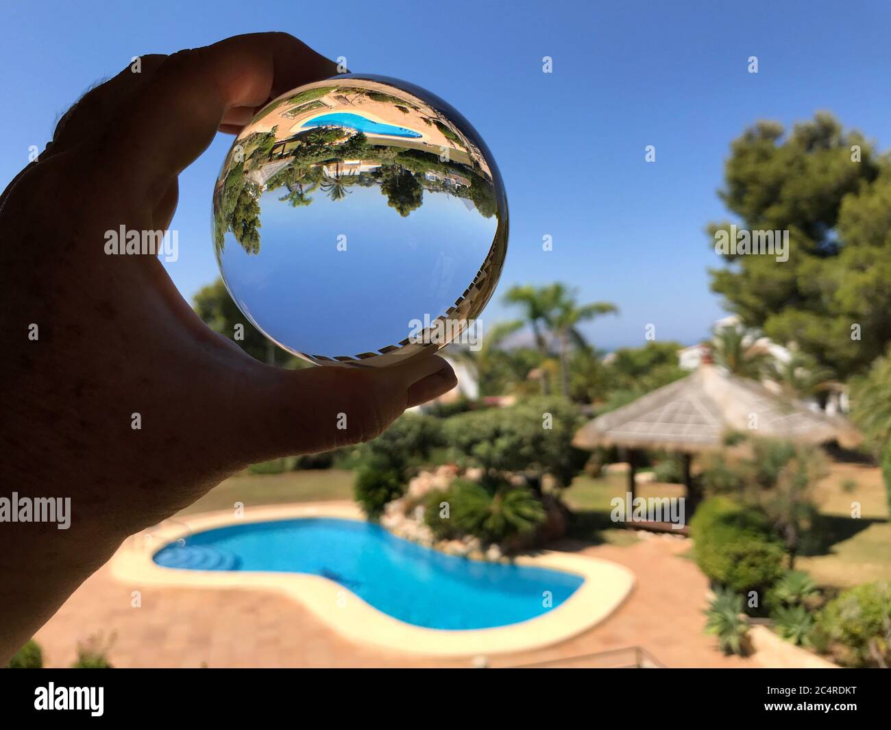 Crystal ball in hand, refraction photography. Looking through lens to a ...