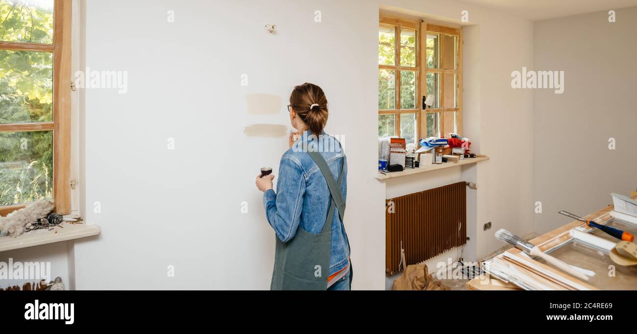 Rear view of a curious woman during the renovation of house apartment ...