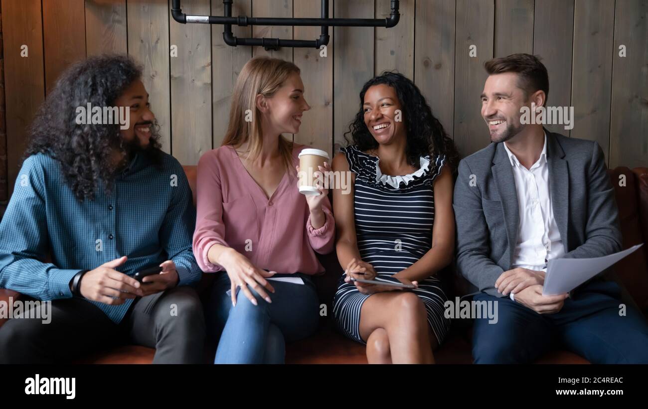 Multiethnic Colleagues Rest In Cafe During Lunch Break Enjoy