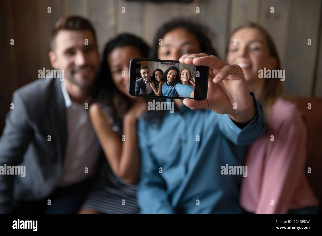 Four multi ethnic friends making selfie, photo smartphone screen view ...