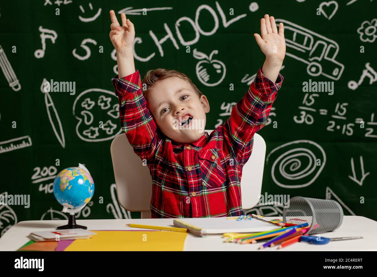 Preschooler boy making school homework. School boy with happy face ...