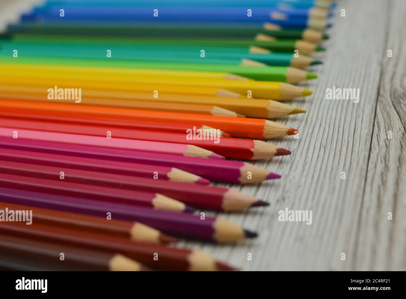 Colored wooden pencils are arranged in a row. A palette of colored ... Colored wooden pencils are arranged in a row. A palette of colored ...
