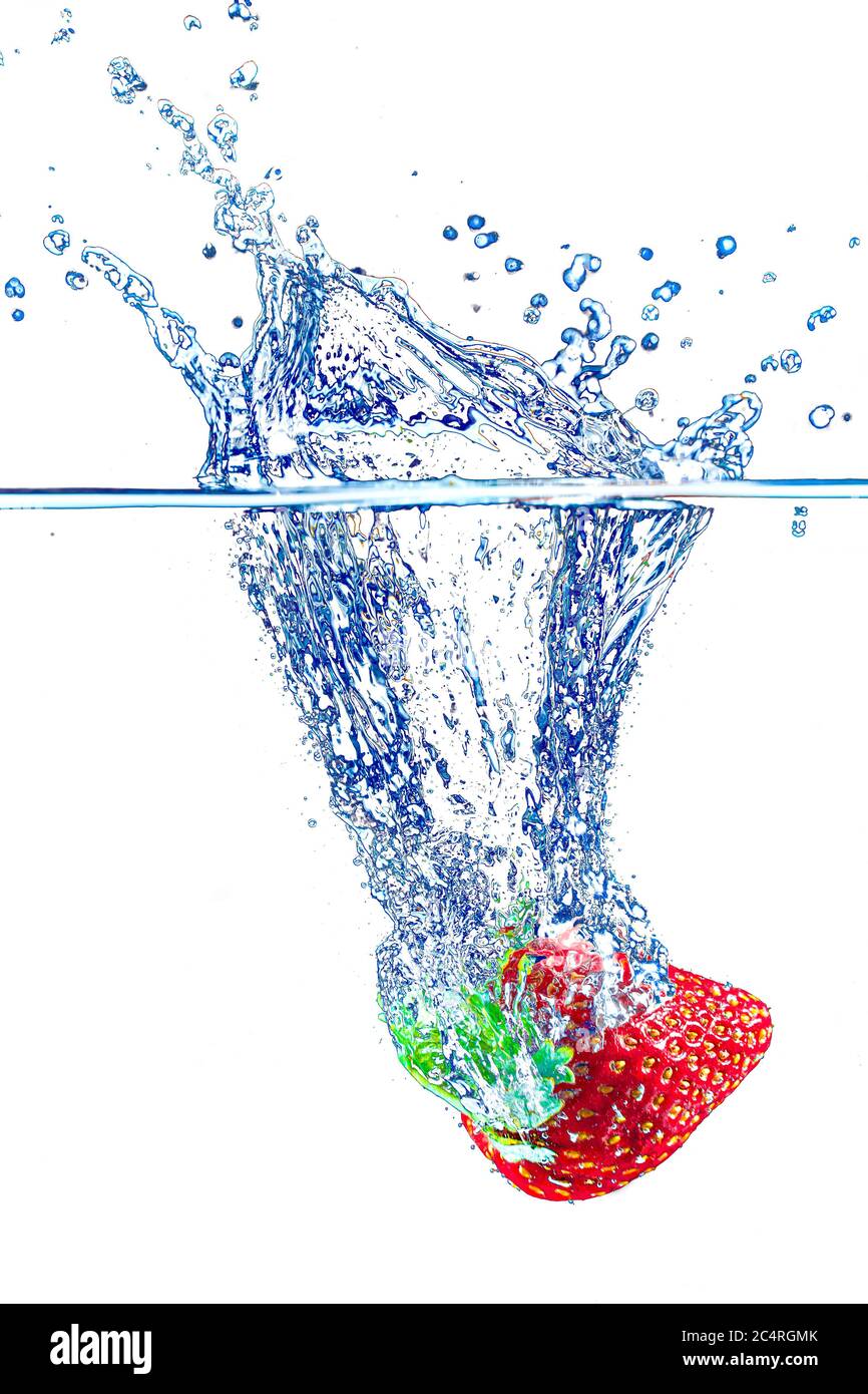 A strawberry splashing into water Isolated on white background Stock ...