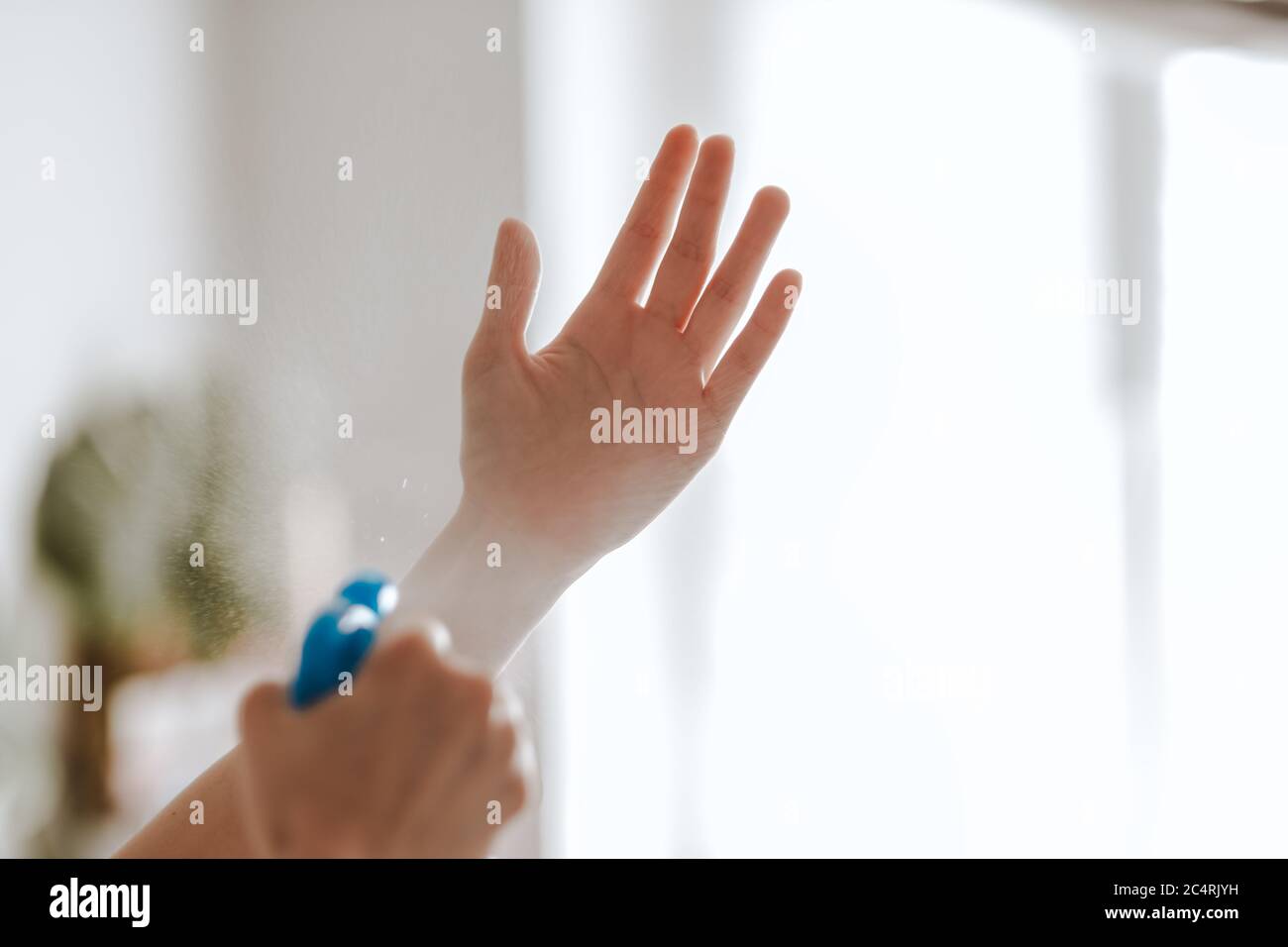 Woman uses a protective spray against germs on her hands Stock Photo ...