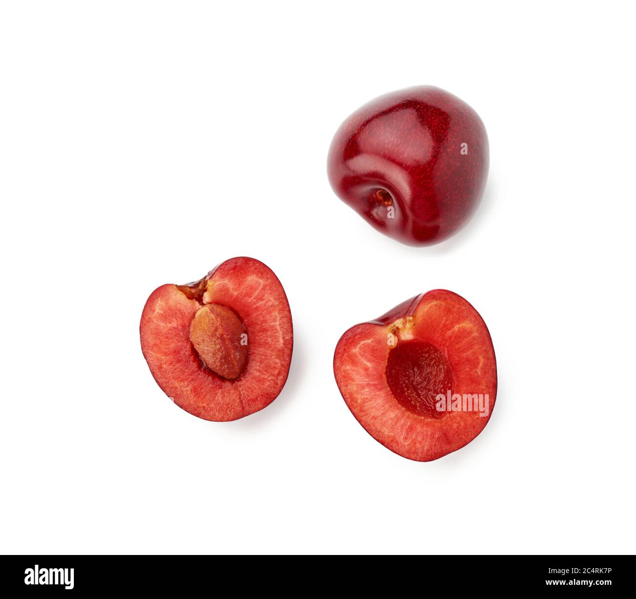 whole ripe red juicy sweet cherries and halves with pits isolated on a ...